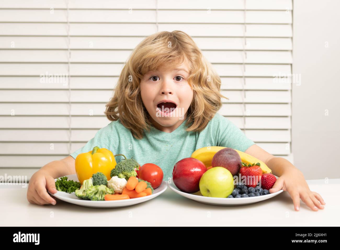 Portrait of preteen child eat fresh healthy food in kitchen at home ...
