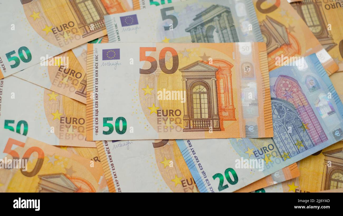 The background consists of many euro banknotes of different ...