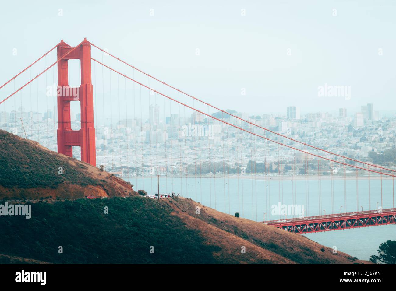 A beautiful closeup of a Golden Gate Bridge tower on a city background ...