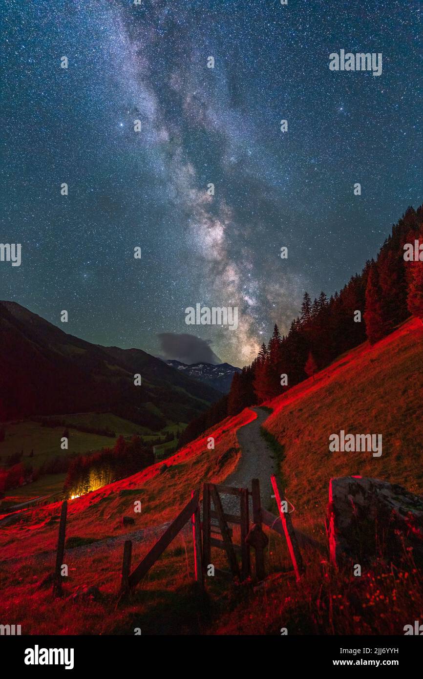 A vertical shot of a path in Fusch valley with the Milky Way galaxy in ...