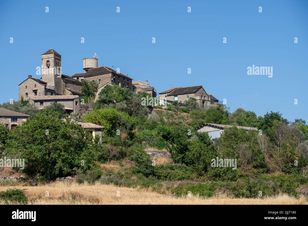 traditional stone-built hilltop village with church and steeple, in the ...