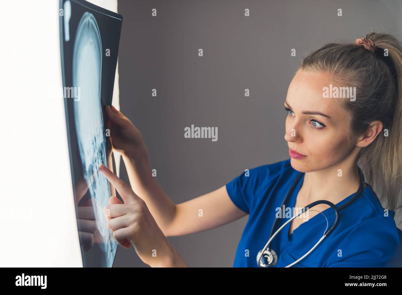 Pretty caucasian female doctor in a blue uniform and stethoscope ...