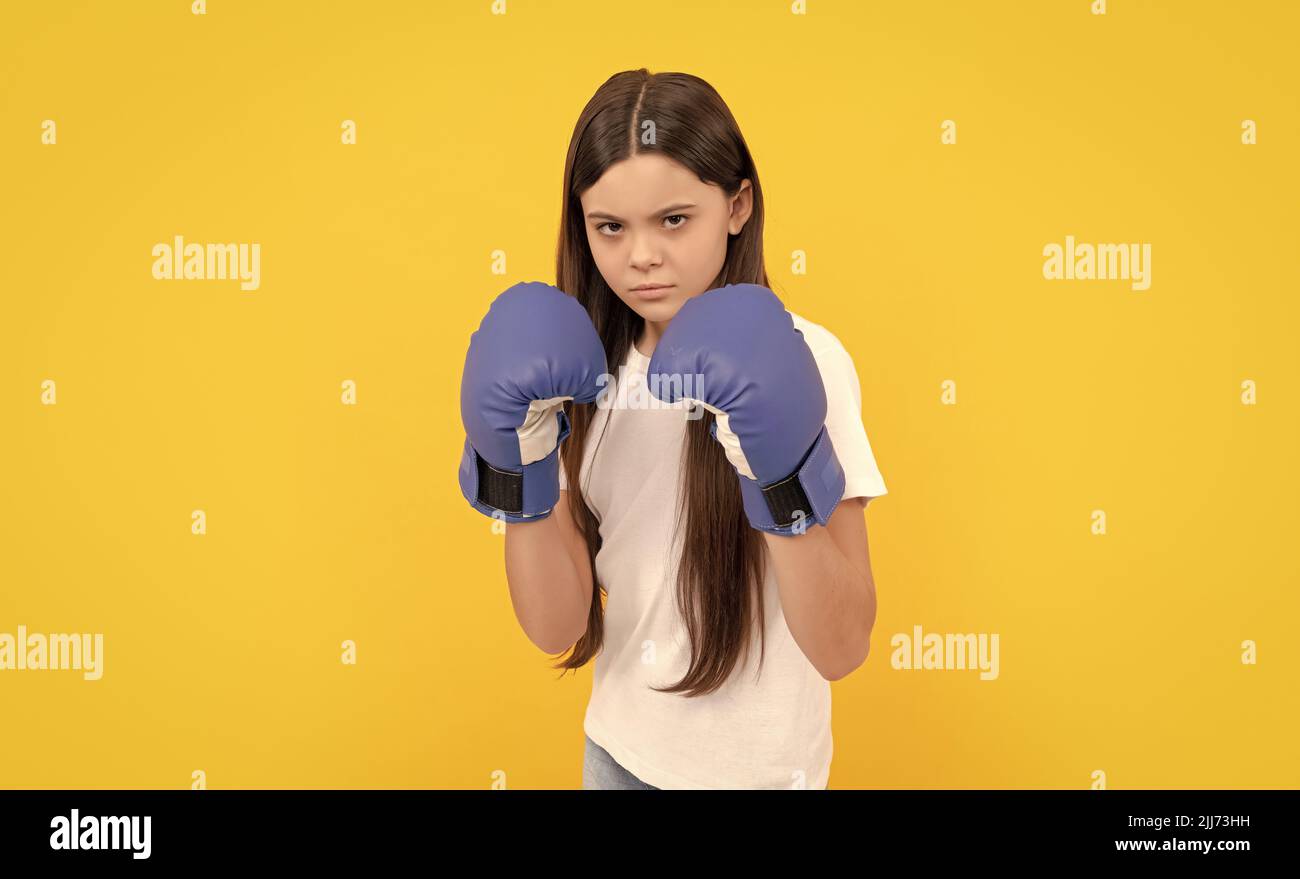 angry child punching in boxing gloves on yellow background Stock Photo ...