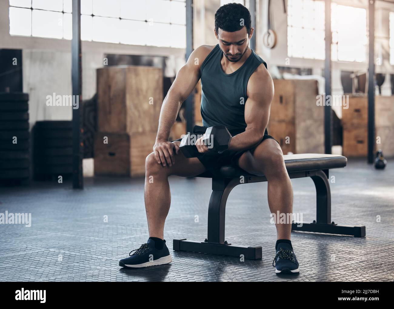 Making gains with every rep. a muscular young man exercising with a ... Making gains with every rep. a muscular young man exercising with a ...