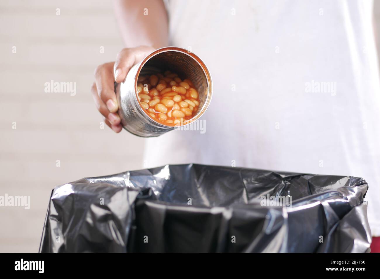 throwing tin container in a garbage bin Stock Photo - Alamy