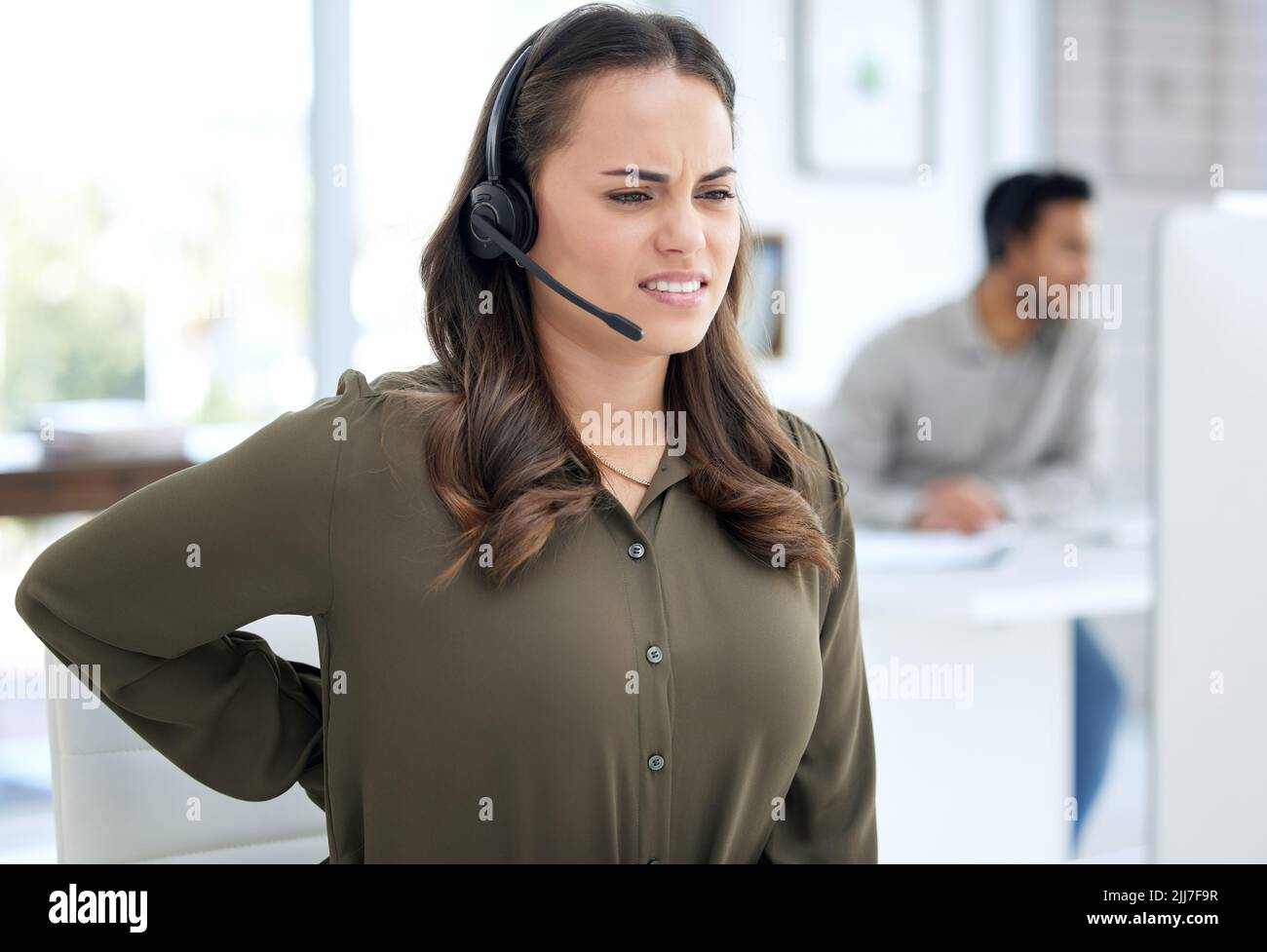 Take a break, your back deserves it. a young businesswoman experiencing ...