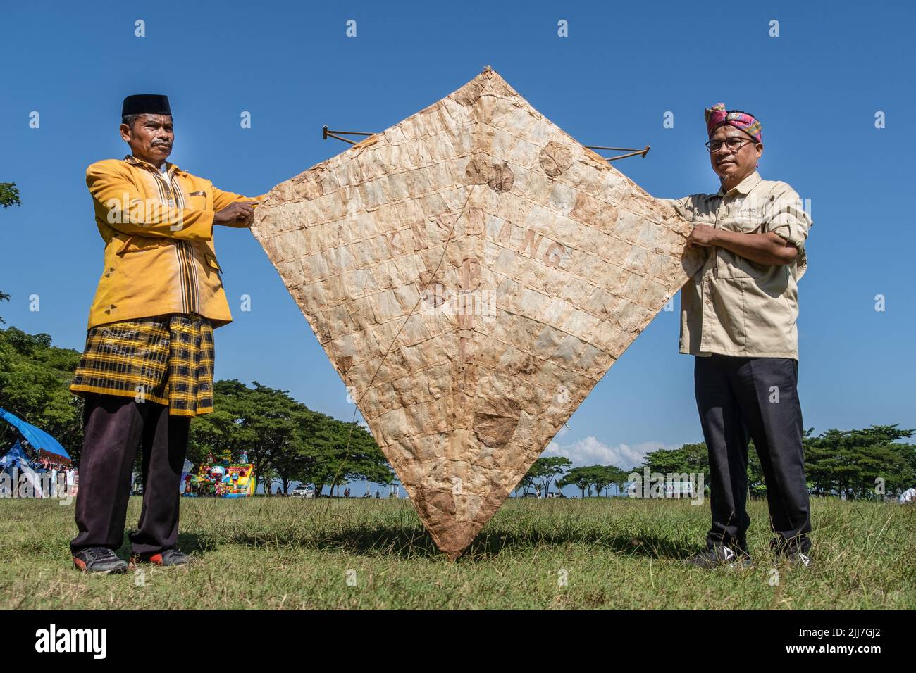 The owner of an ancient kite shows his kite before it is flown. The ...