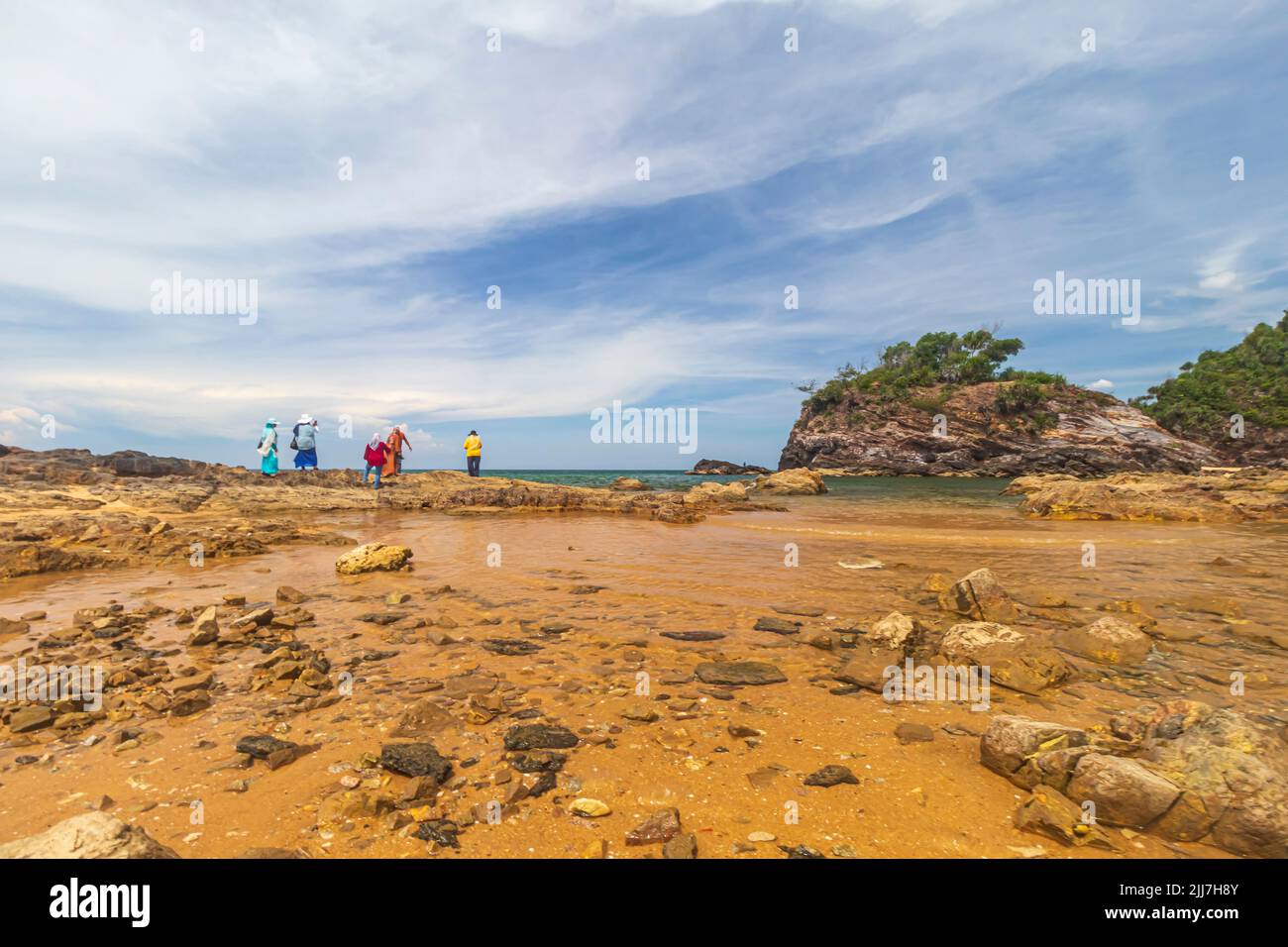 Beach view with rock outcrops in shallow water by the beach and rock ...