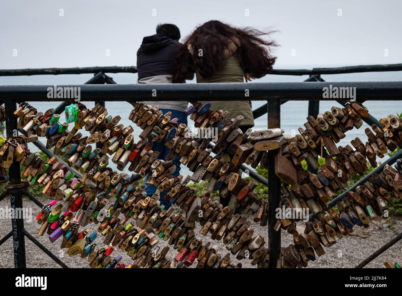 A couple looks out at the Pacific Ocean at El Parque del Amor (park of ...