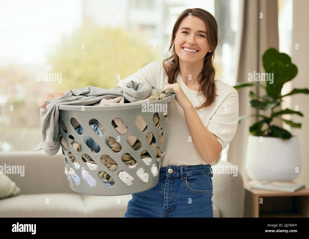 clean laundry hypes her up. a young woman doing laundry at home Stock Photo - Alamy