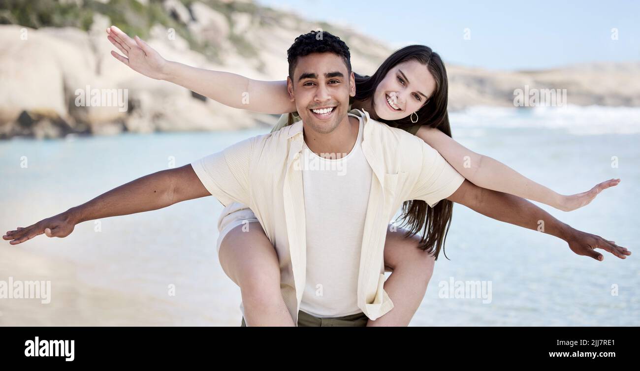 Lets fly away together. a young couple enjoying a day at the beach ...