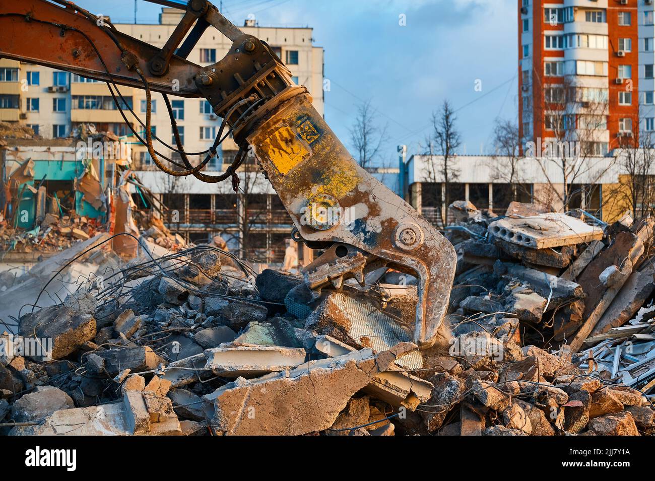 Crusher destroys reinforced concrete at demolition site Stock Photo - Alamy