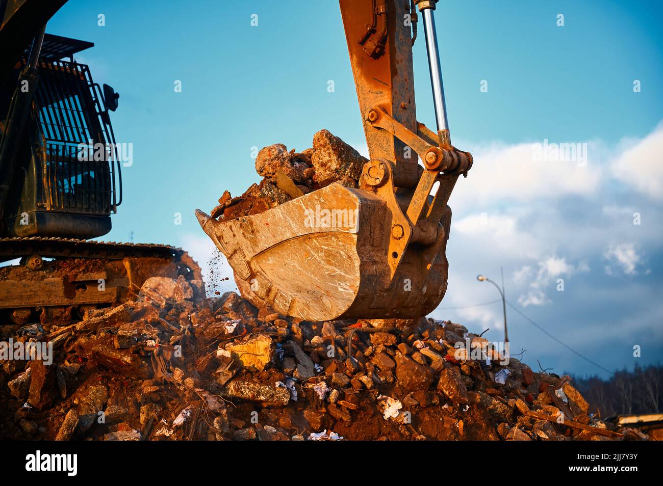 Scoop of building excavator full of concrete stone leftovers Stock Photo - Alamy