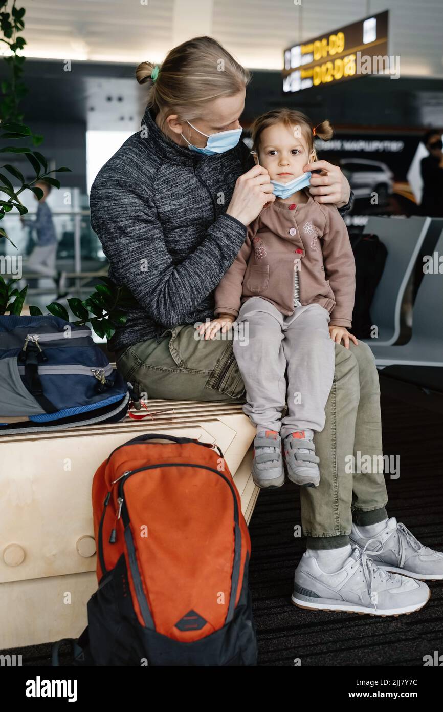 Father putting face mask on Childs face at the airport. Man protects ...