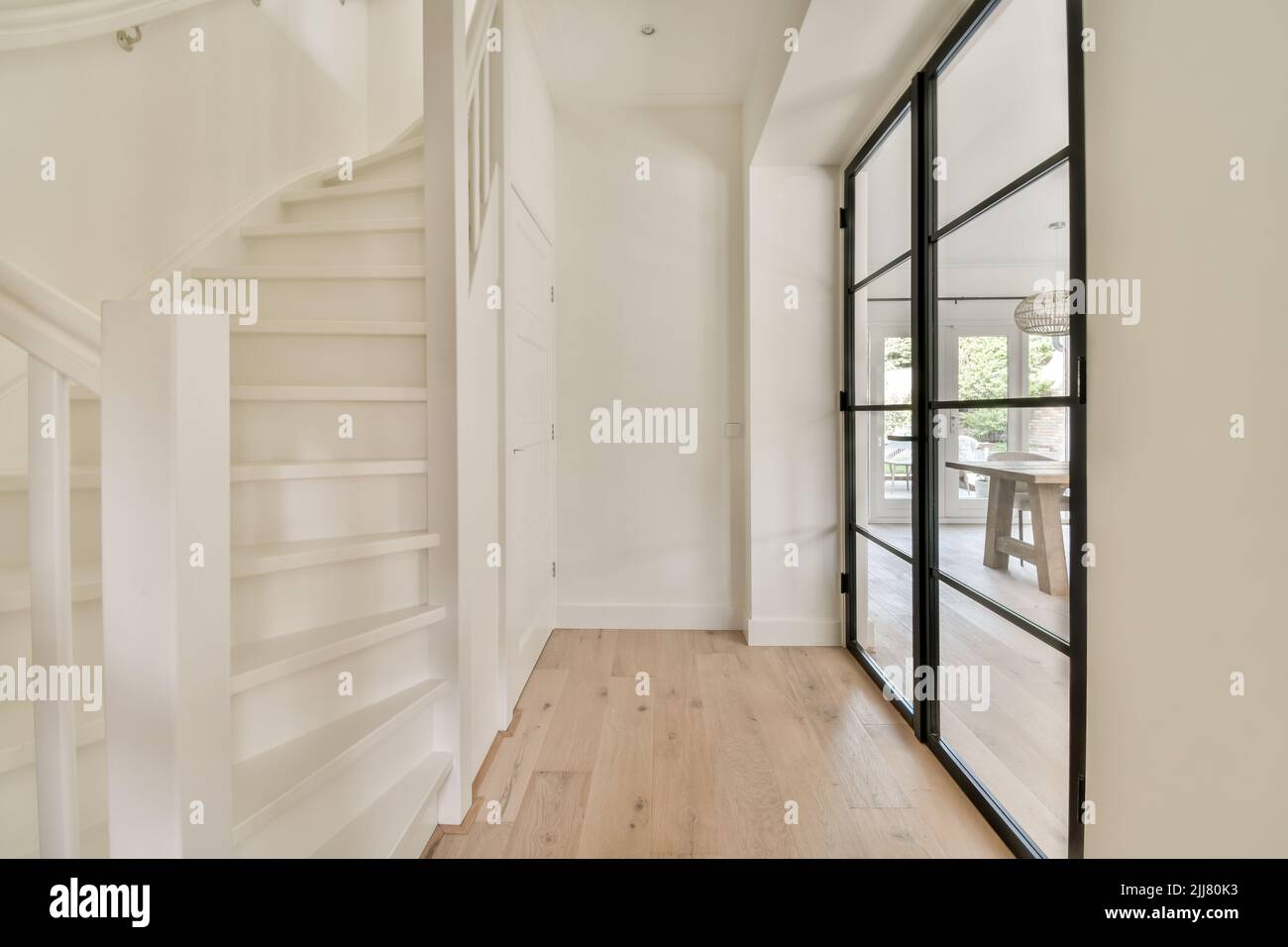 From above of narrow spiral stairway with white stairs and railing on ...