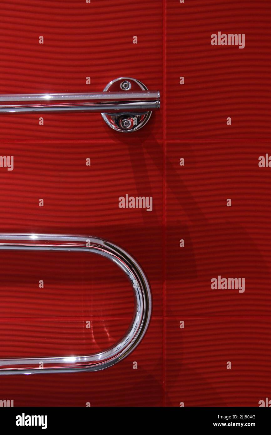 Glossy chrome radiator part built in a bathroom wall Stock Photo - Alamy