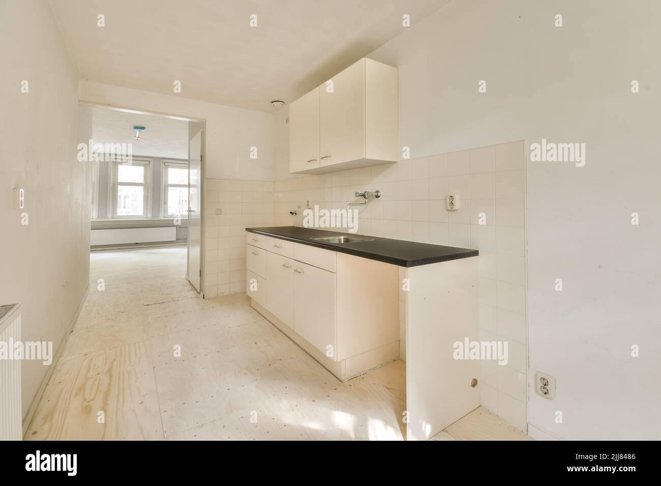 Interior of empty white kitchen with windows and wooden parquet floor ...