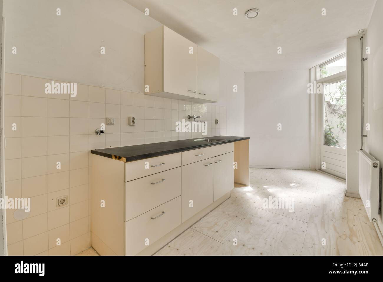 Interior of empty white kitchen with windows and wooden parquet floor ...