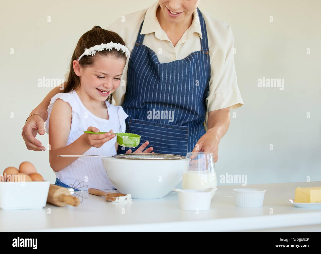 Shes a natural cook. a little girl helping her parent cook in the ...