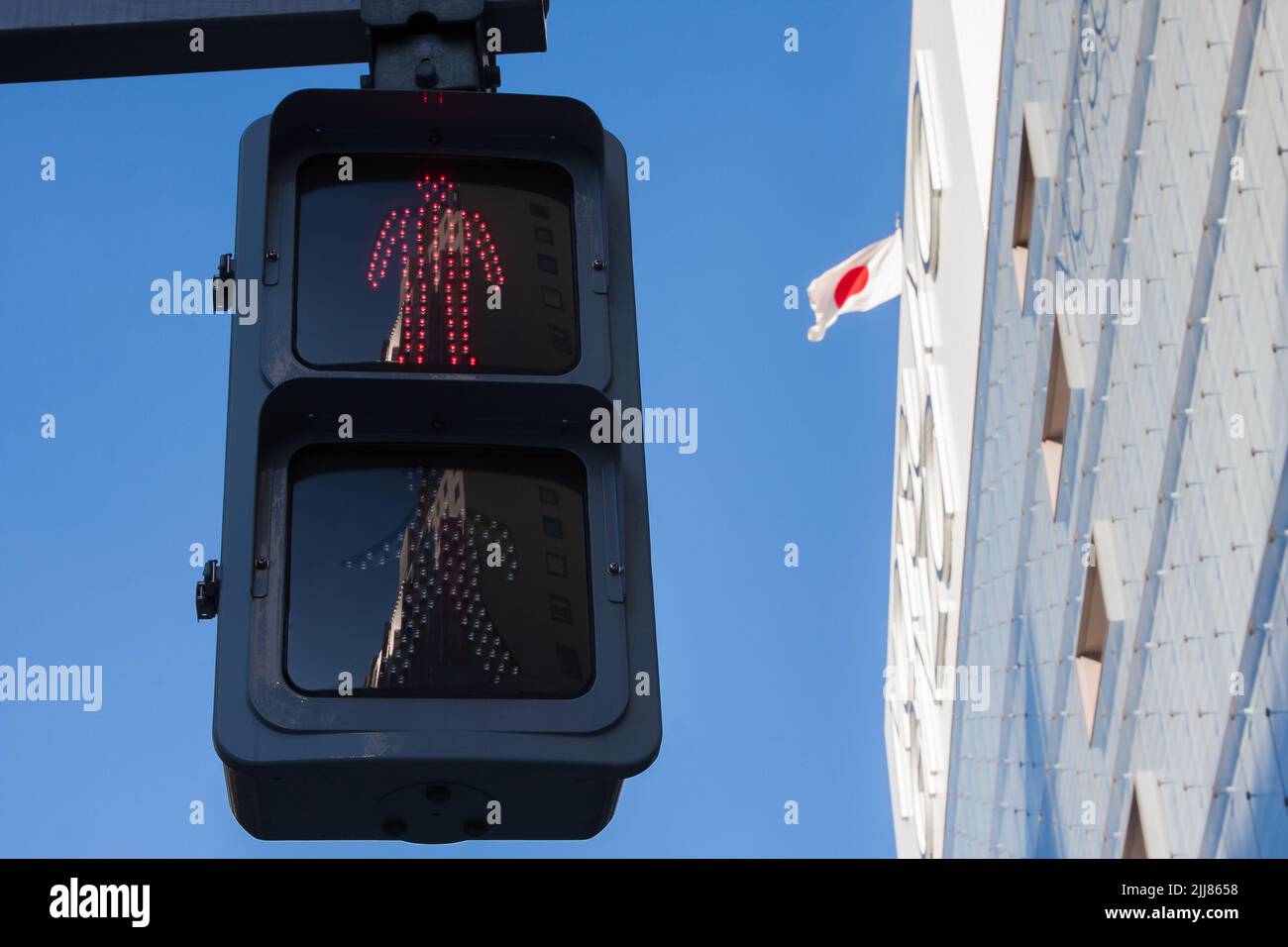 A Japanese pedestrian crossing signal showing a red figure meaning ...