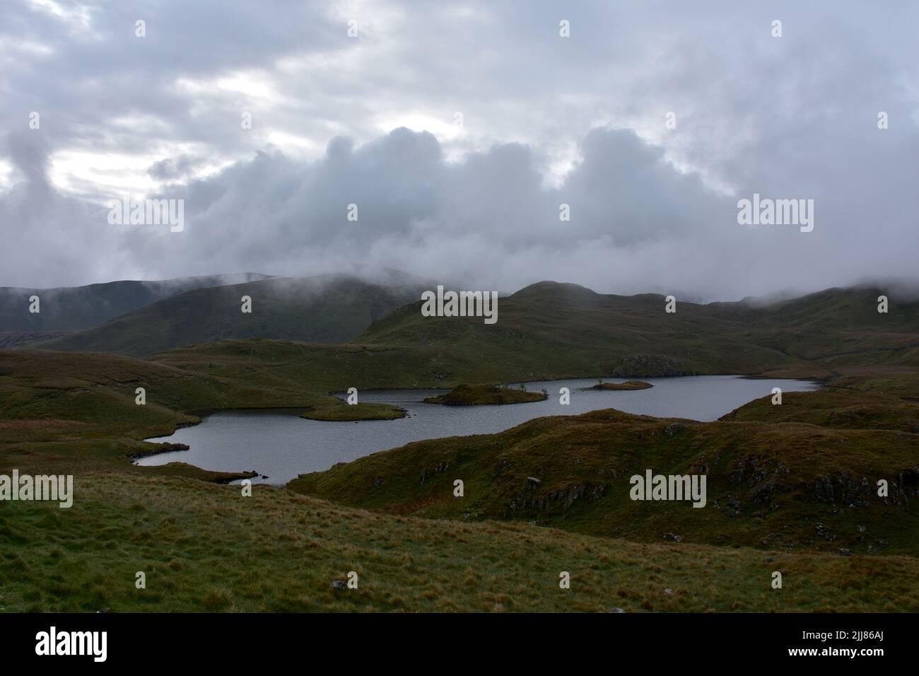 Fog and clouds lifting off Angle Tarn in England Stock Photo - Alamy
