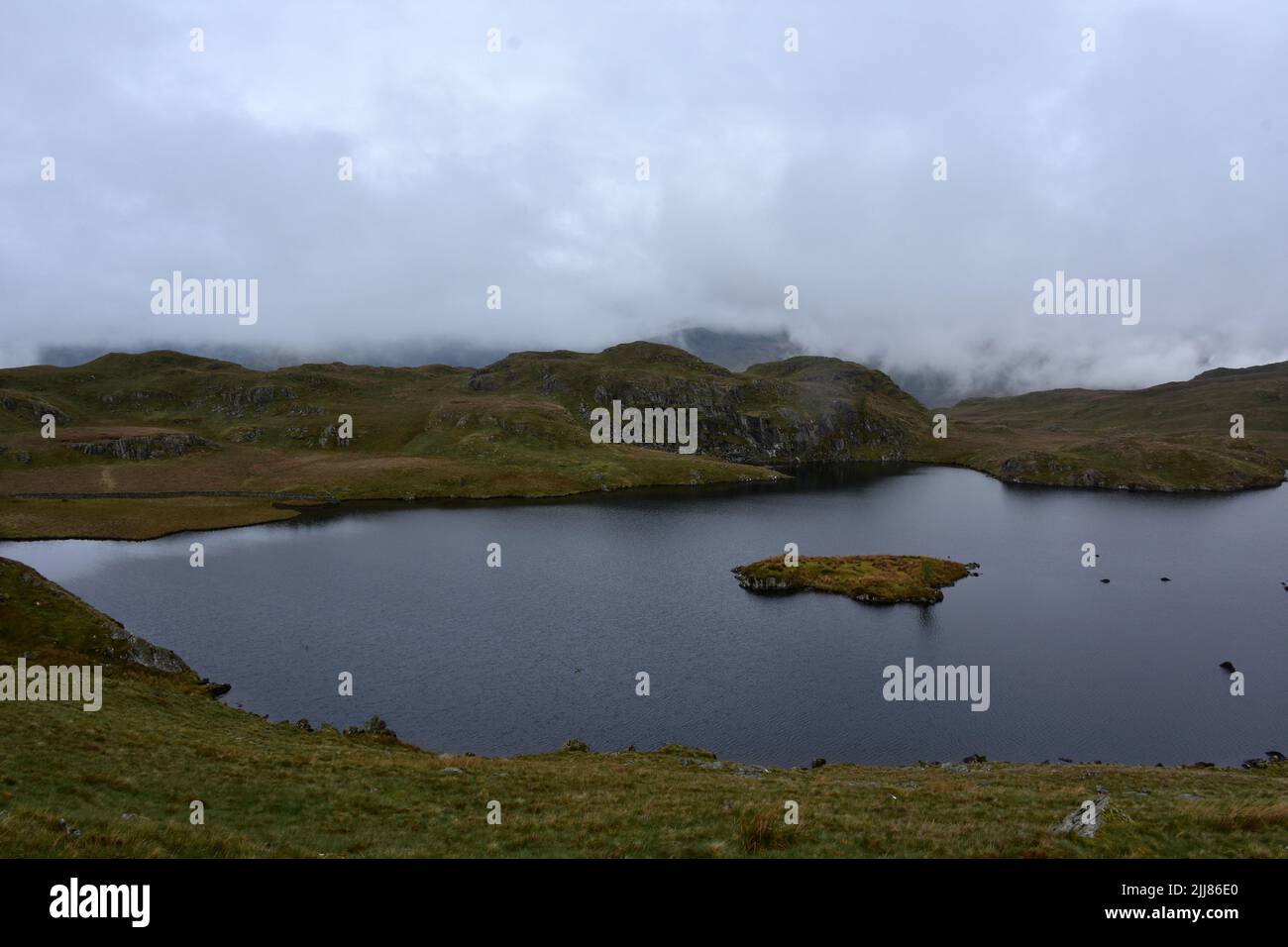Angle tarn with thick clouds and fog on mountain top Stock Photo - Alamy