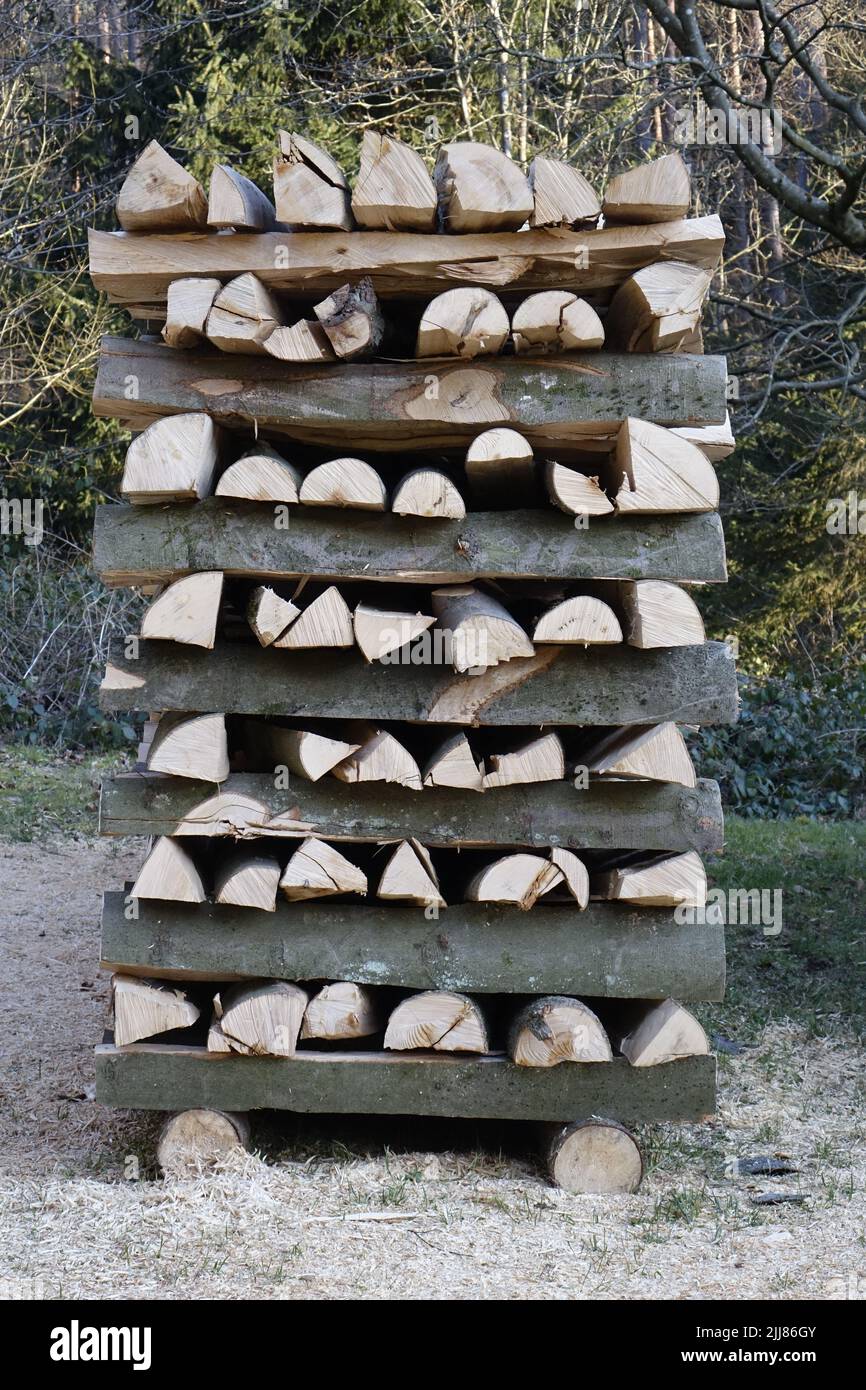 A vertical shot of pile of dry chopped firewood stacked on top of each ...