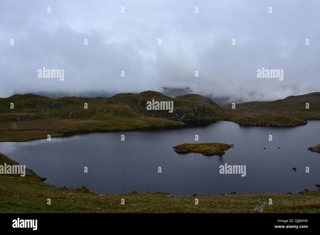 Thick fog at Angle Tarn on top of a fell in England Stock Photo - Alamy