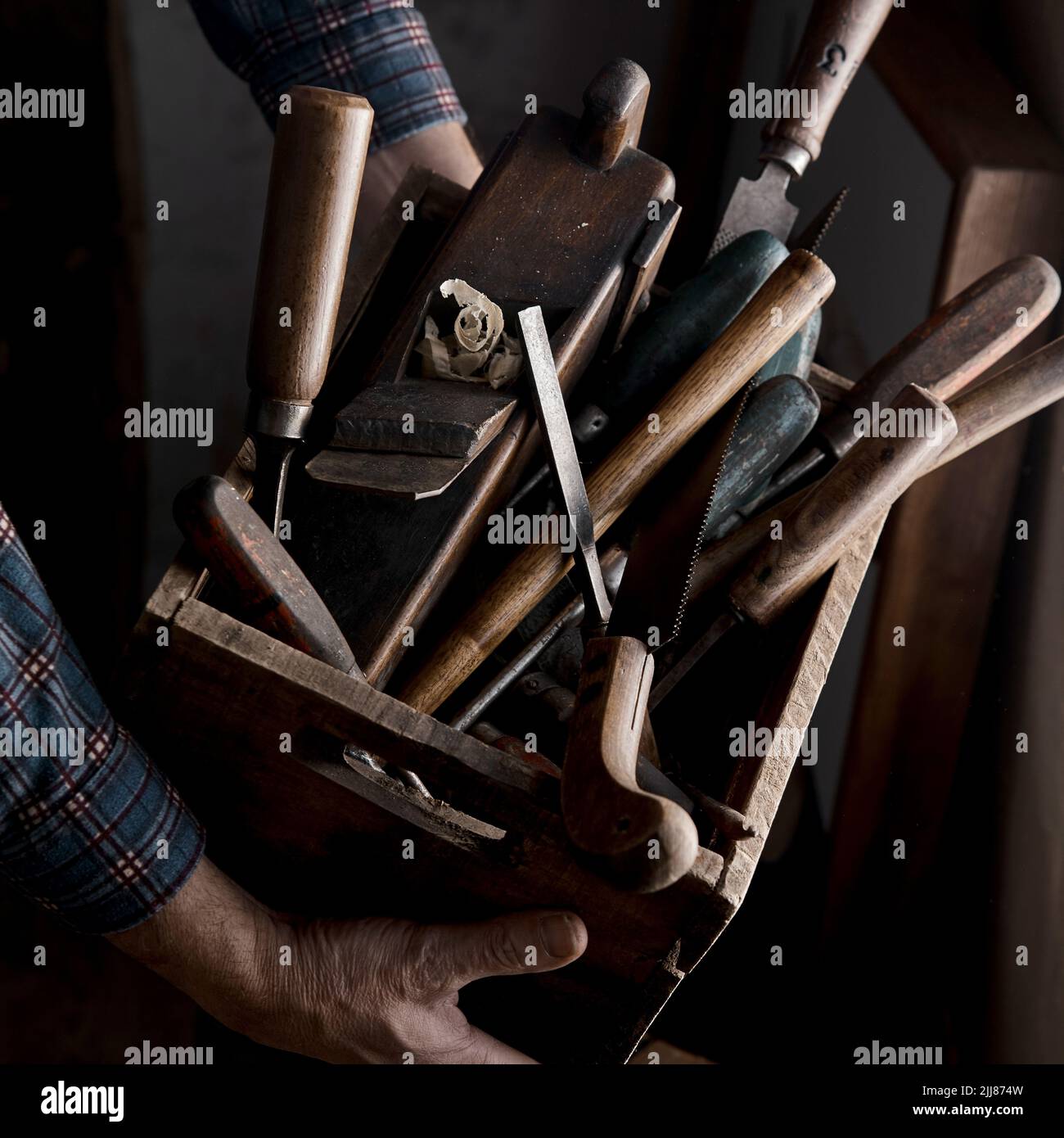 From above of crop male carpenter with wooden box full of various ...