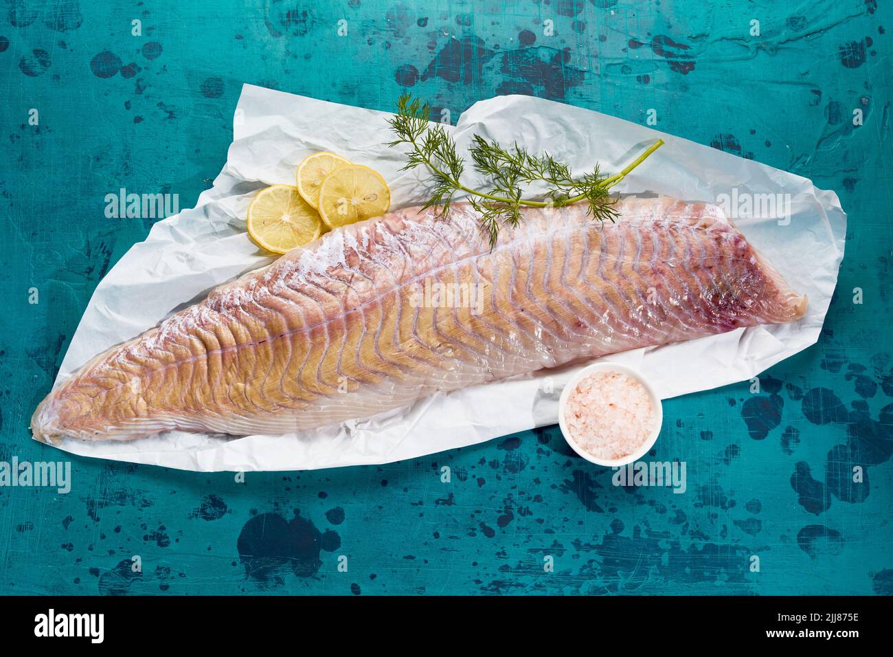 Top view of fresh fish fillet placed on blue background with lemon ...