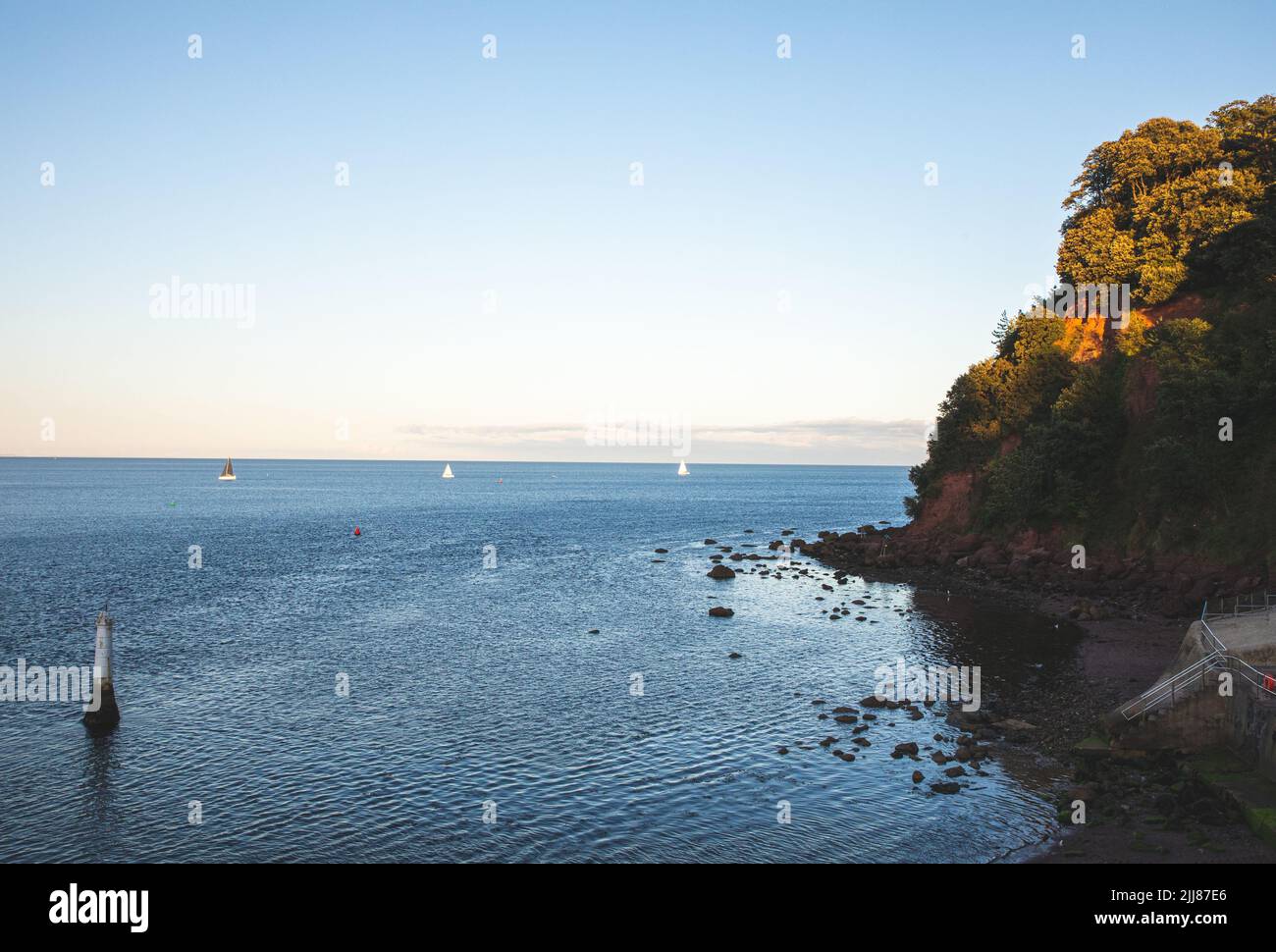 A bird's eye view of a cliff with trees by the lake Stock Photo - Alamy