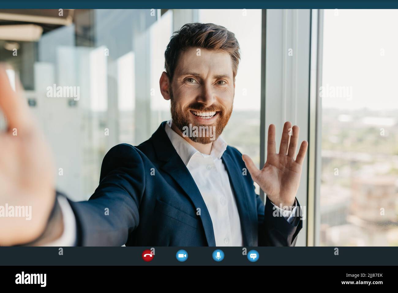 Positive businessman making video call from office, waving hand at ...