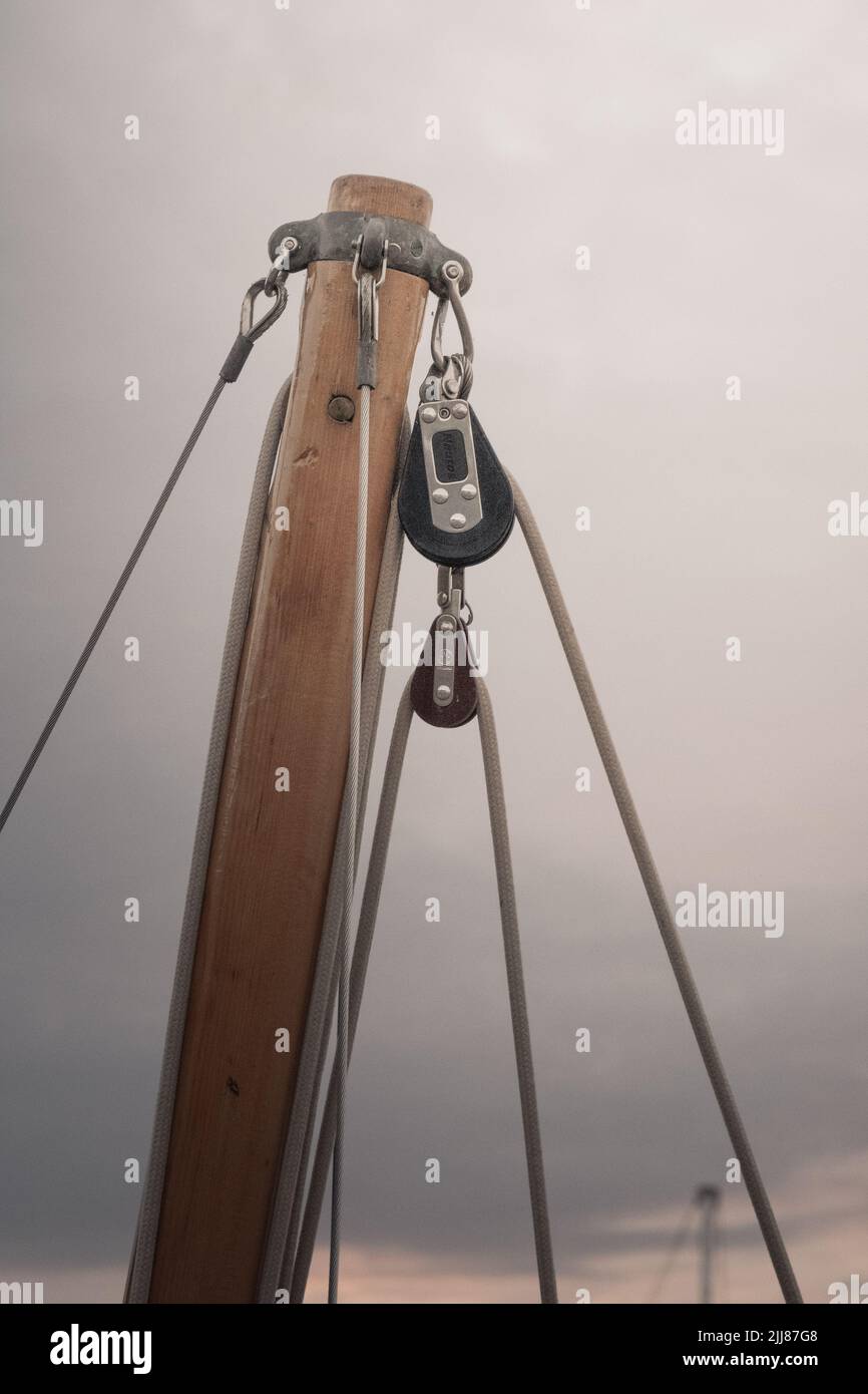 A vertical close-up shot of the rigging on a mast of a sailing yacht ...