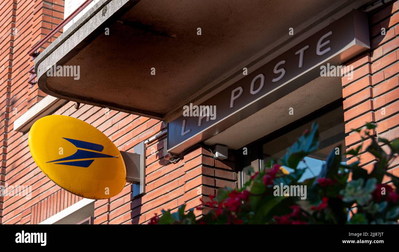 Logo and sign of the French company La Poste on the facade of a post ...