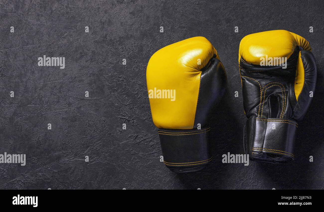Yellow boxing gloves on a black background Stock Photo - Alamy