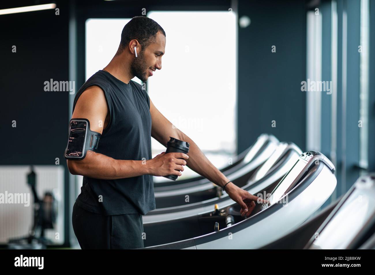 Portrait Of Handsome Black Male Athlete Turning On Treadmill Before ...