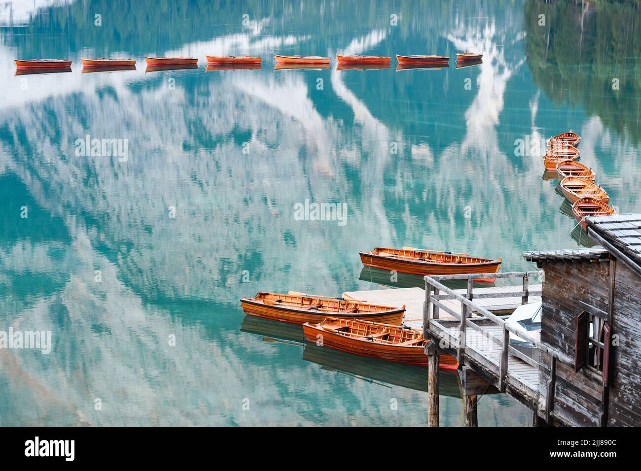Stunning view of the Lake Braies (Lago di Braies) with some wooden boats and beautiful mountains ...