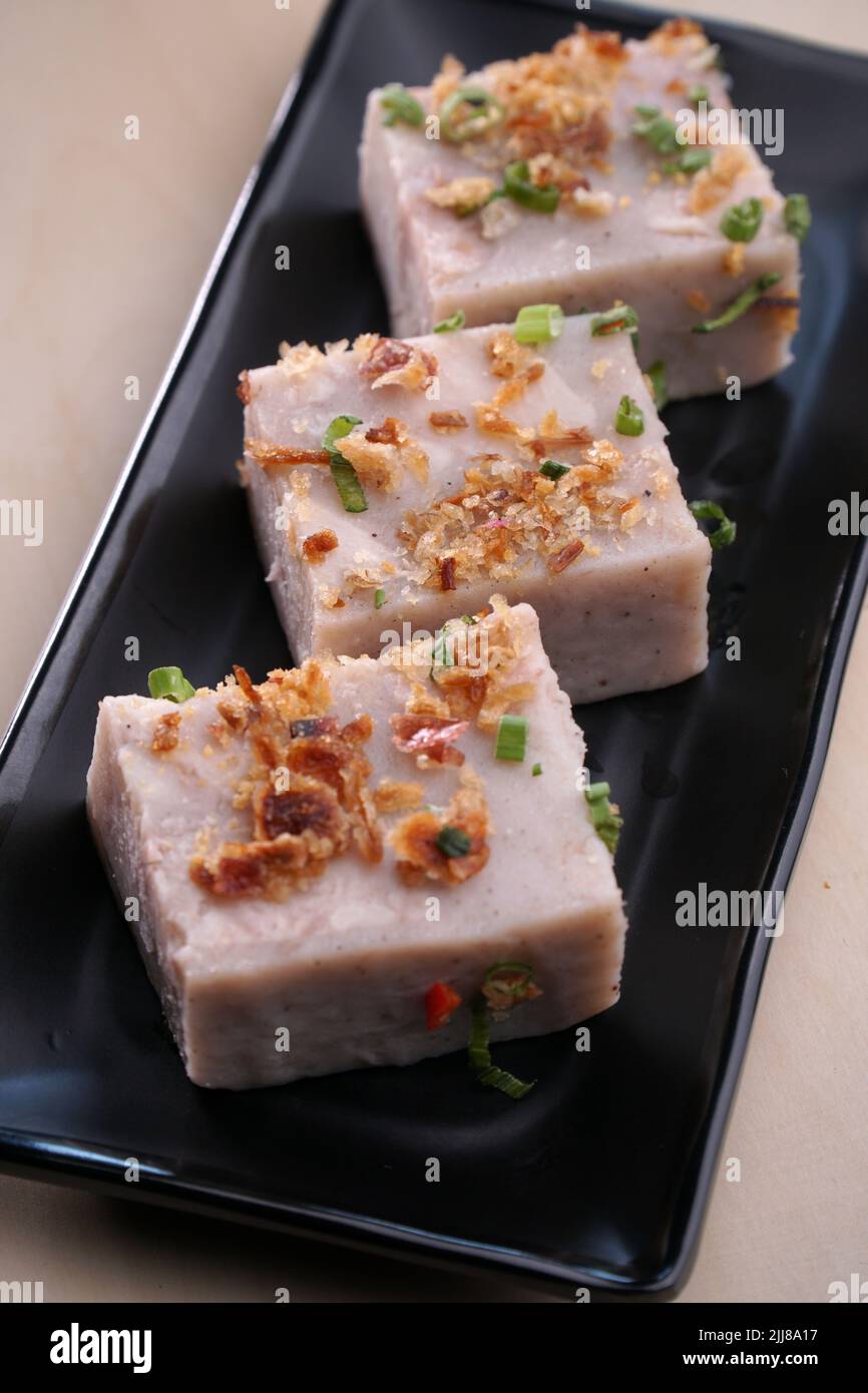 A vertical closeup of taro cakes served on a black plate Stock Photo ...