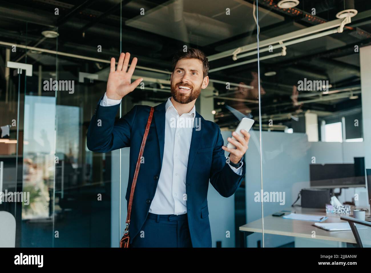 Happy male office worker in suit entering office space smiling and ...