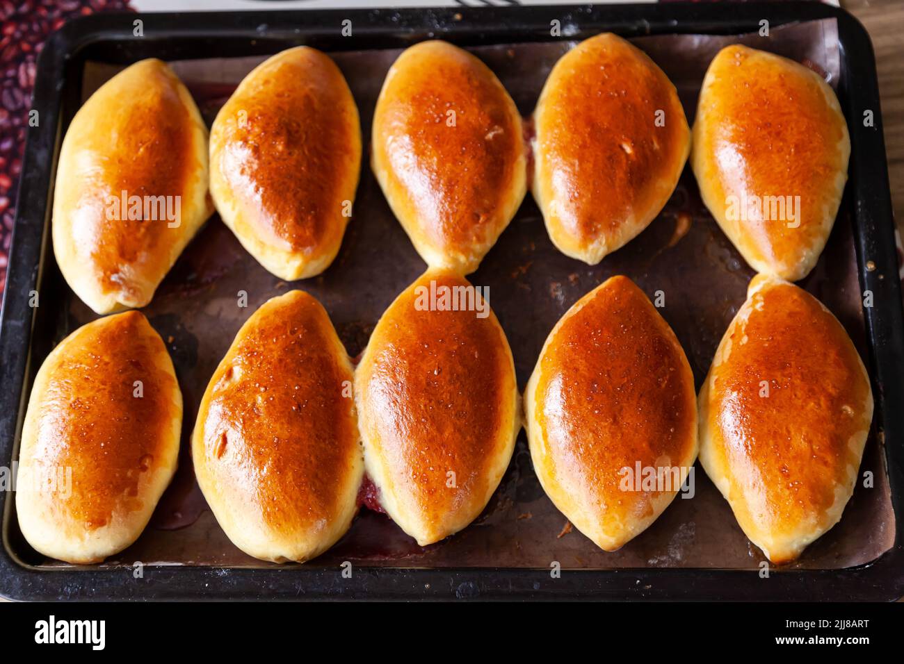 Russian meat piroshki. Traditional hand mini pies on wooden background ...