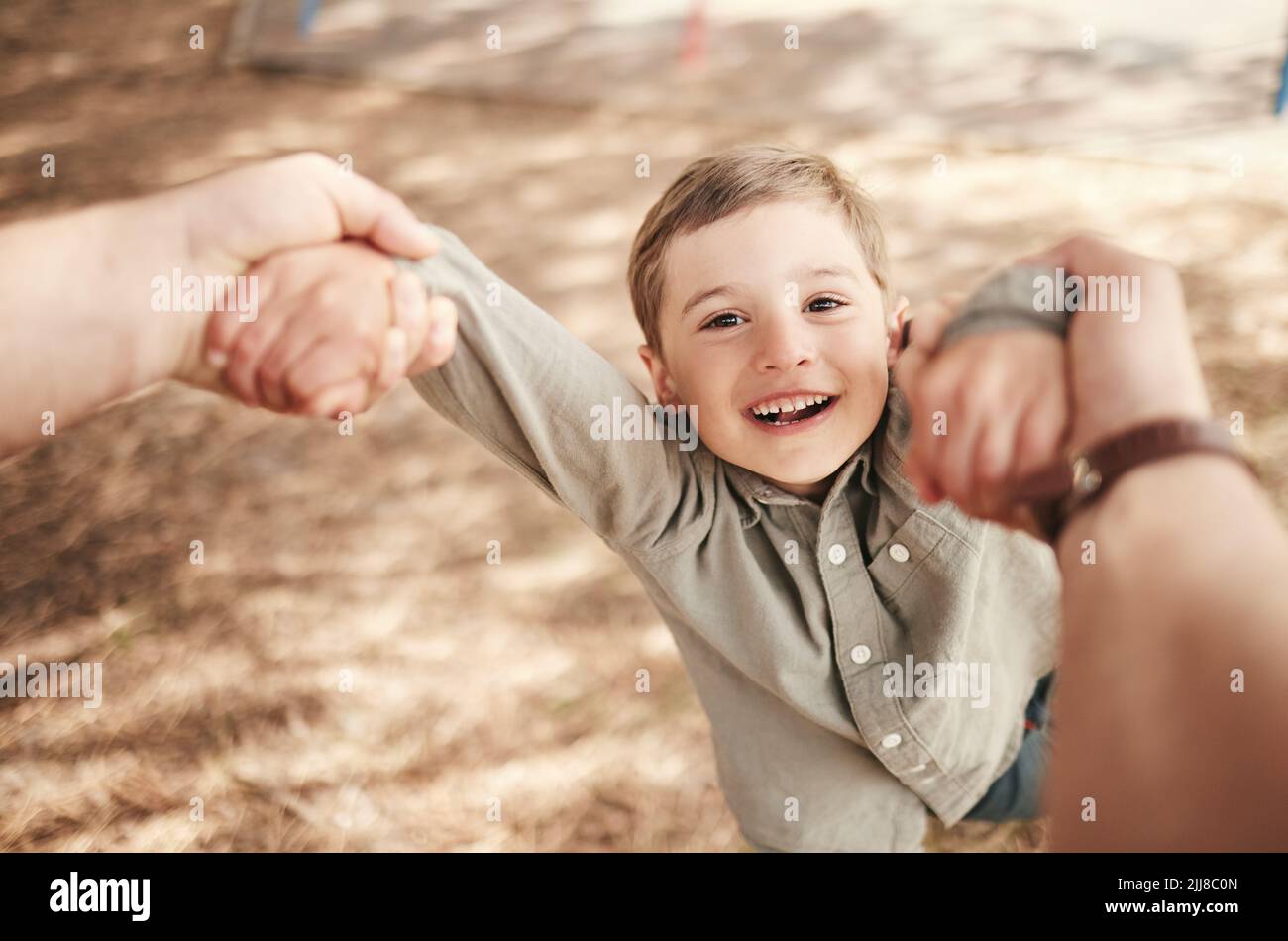 Close up face of happy caucasian boy swinging and spinning in circles ...