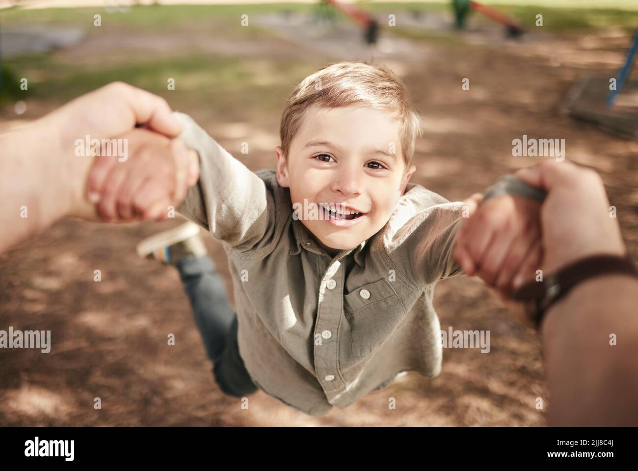 Close up face of happy caucasian boy swinging and spinning in circles ...