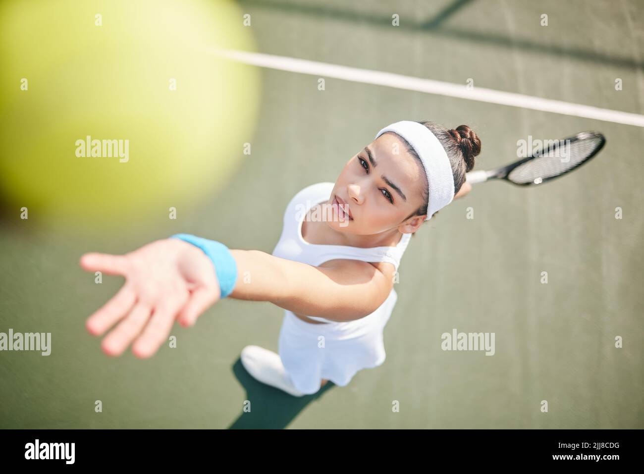 My serve needs to be perfect. High angle shot of young tennis player ...