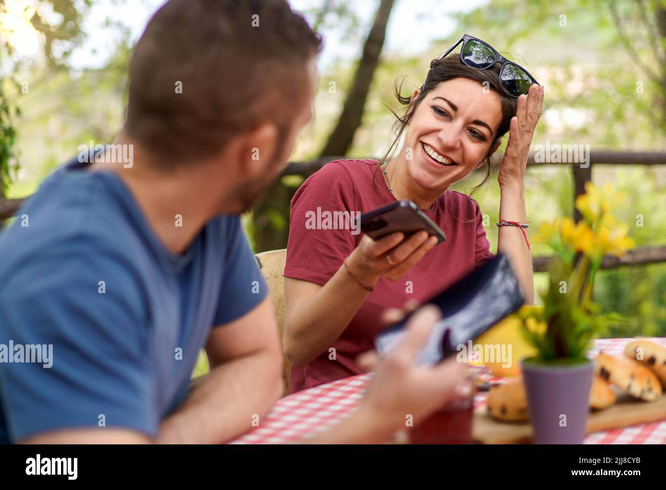 Happy couple of friends chatting carefree sitting at farmhouse ...