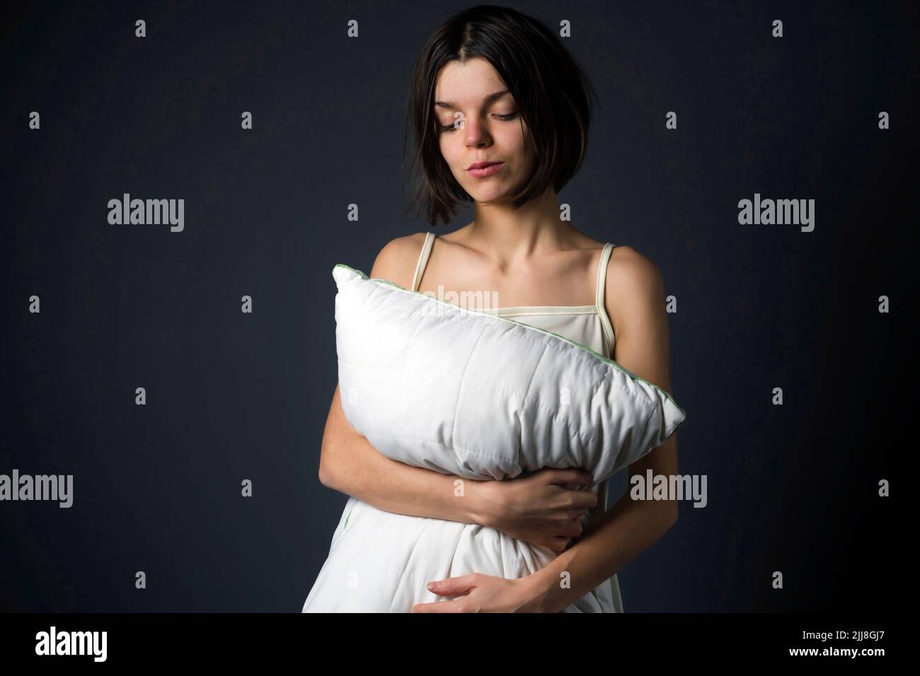 Girl hugs a white soft pillow and wants to sleep Stock Photo - Alamy