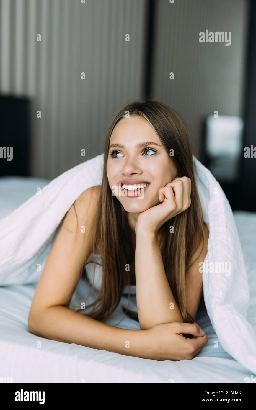 Beautiful woman in bed under the sheets Stock Photo - Alamy
