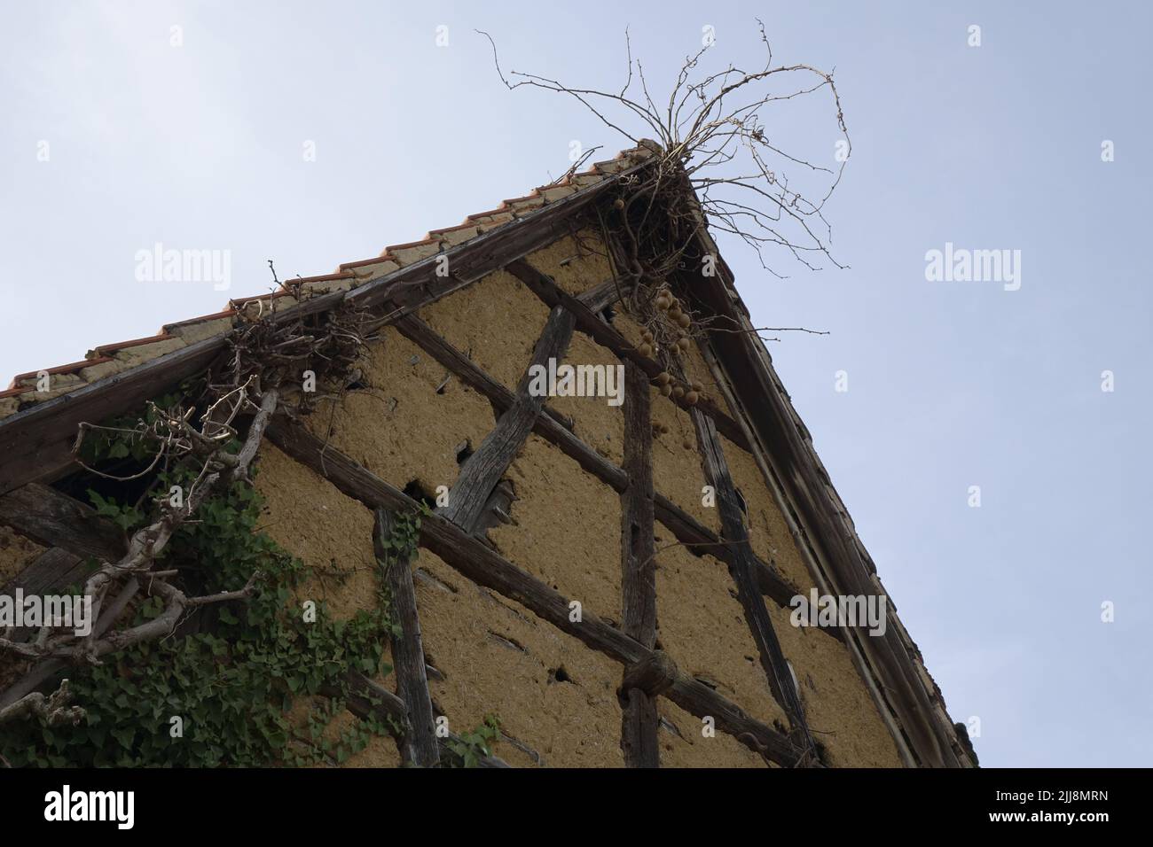 A low angle shot of gable roof of old framework house with ochre adobe ...