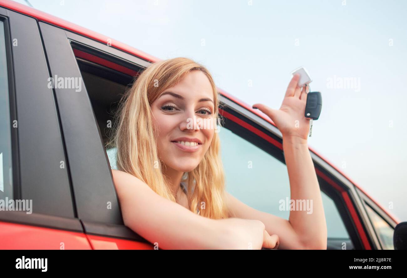 Car driver woman smiling showing new car keys and car Stock Photo - Alamy