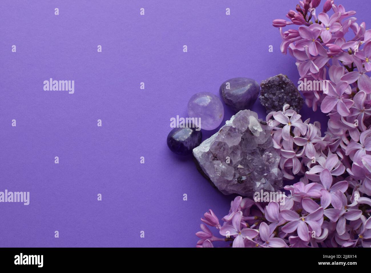 Beautiful lilac flowers and semi-precious amethyst druze lie on a ...