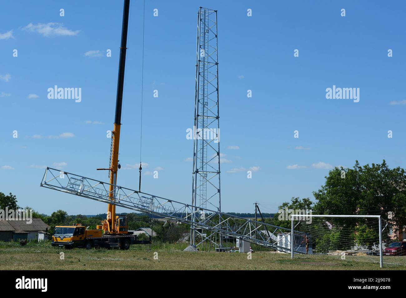 A team of fitters using a crane assembles a metal structure of a ...